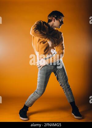 Young and muscular man performing a contemporary dance pose on a stage ...