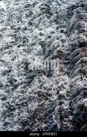 Closeup of rough river water surface with water splashes in neo mint ...