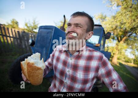 Hungry caucasian senior driver eating patty while sitting inside his ...