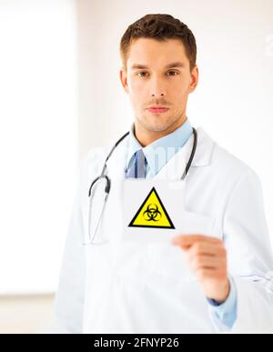 male doctor holding boihazard caution sign Stock Photo - Alamy