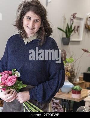 Young business woman wearing purple jacket over pink background smiling ...