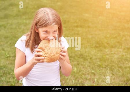 Child holds and bite round bread. Healthy food Stock Photo - Alamy