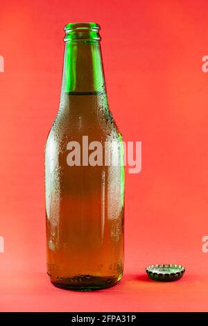 A glass mug containing an amber liquid sits on a dark surface ...