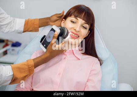 Dermatologist with magnifier examining patient in clinic, closeup Stock ...