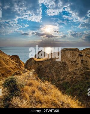 Precipice coast near the sea. The clay cliff on the seashore. Visiting ...