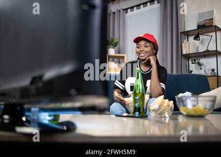Happy woman fan football spending time in supporting her football team ...