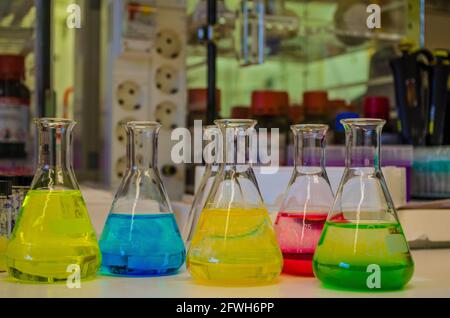 Different colorful solution in conical flask on a bench in a chemistry ...
