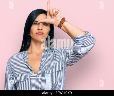 A woman making the loser sign with her hand Stock Photo - Alamy