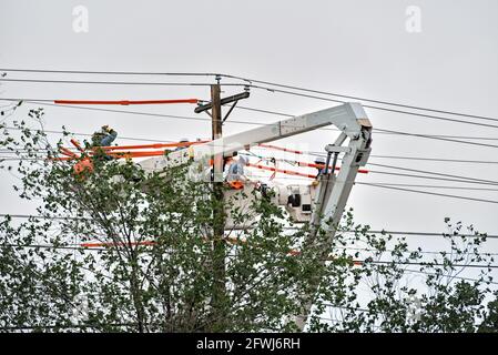 electrical lineman connecting wires high on electric pole. powerline ...