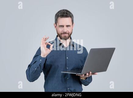 Computer programmer show ring gesture holding portable laptop grey background, OK Stock Photo ...