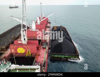 Transporting coal from the barge to the mother vessel aerial view Stock ...