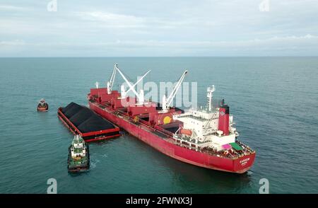 Transporting coal from the barge to the mother vessel aerial view Stock ...
