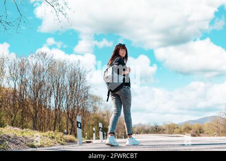 Local Travel and hitchhiking. Pretty young woman in a cap and ...