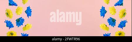 A rain of blue and yellow flowers falls against pastel pink background ...