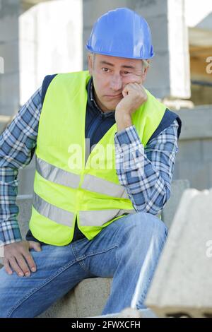 Unhappy dissatisfied construction worker on a ladder Isolated on white ...