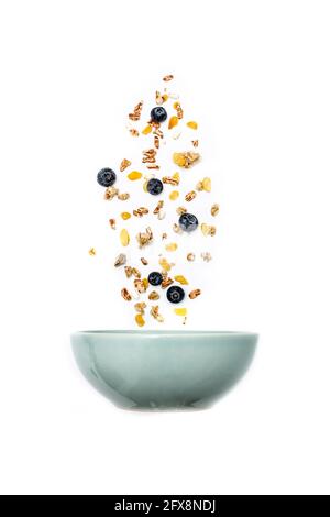 Cereals falling in a white bowl on a wooden table Stock Photo - Alamy