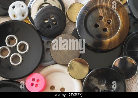 A pile of buttons of various shapes and sizes. The buttons are ...