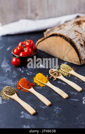 Wooden spoons with spices, paprika, basilic, pepper, thyme with cherry ...