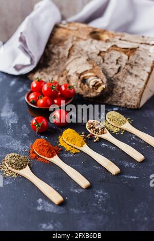 Wooden spoons with spices, paprika, basilic, pepper, thyme with cherry ...