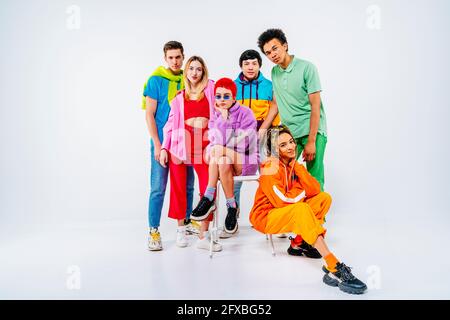 Young redhead woman sitting over brick wall wearing birthday hat with ...