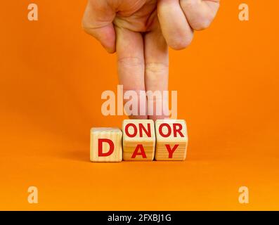 Donor day symbol. Doctor turns wooden cubes with words 'Donor day ...