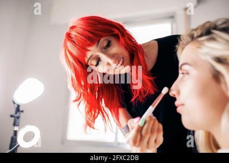 side view of beautiful female artist painting in workshop Stock Photo ...