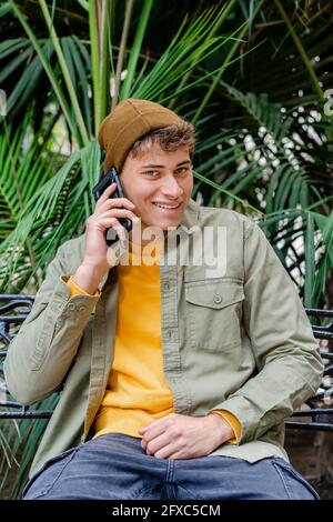 Smiling man wearing knit hat standing with eyes closed Stock Photo - Alamy