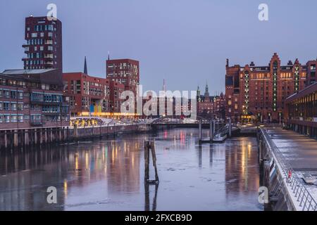 Germany, Hamburg, Frozen waters of Brooktorhafen at dusk in winter ...