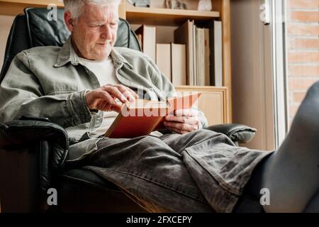 Spain, Senior man reading book Stock Photo - Alamy