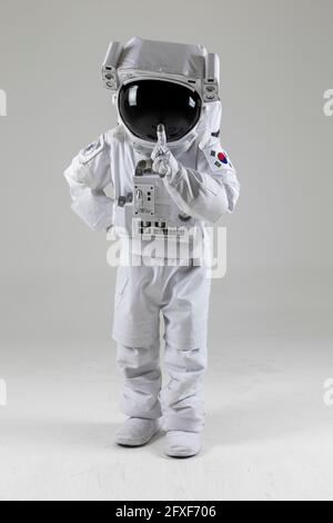 Astronaut asking for silence, white background Stock Photo - Alamy