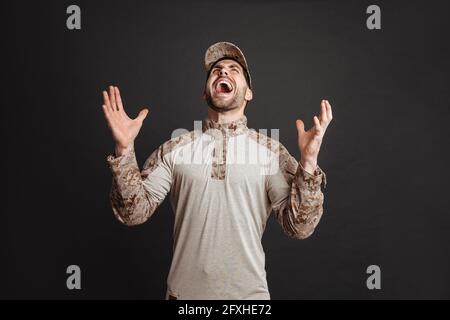 Furious masculine military man screaming with his hands up isolated ...