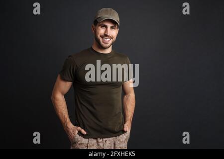 Happy masculine military man smiling and looking aside isolated over ...