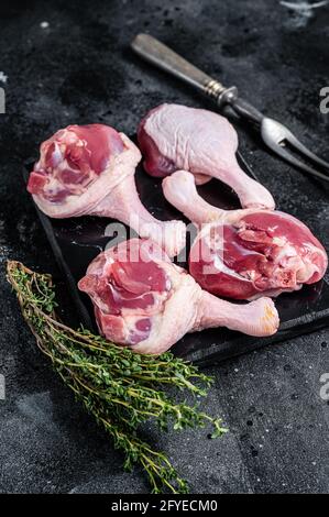 Uncooked Raw Duck legs drumsticks on marble board. Black background ...