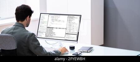 Programmer Or Coder At Office Desk Using Laptop Stock Photo - Alamy
