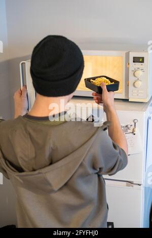 Man using the microwave Stock Photo - Alamy