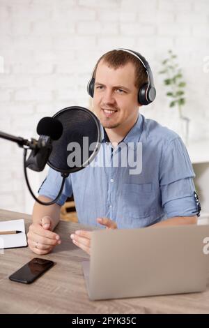 Radio, DJ, blogging and people concept - Smiling man sitting in front ...