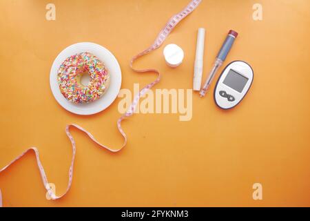 diabetic measurement tools, insulin and donuts on white background ...