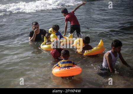 Palestinians enjoy the beach of the Mediterranean Sea during a heat ...