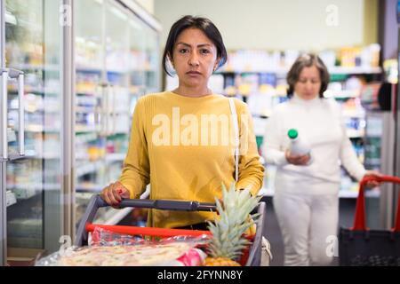 Portrait of positive interested latin american woman visiting ...