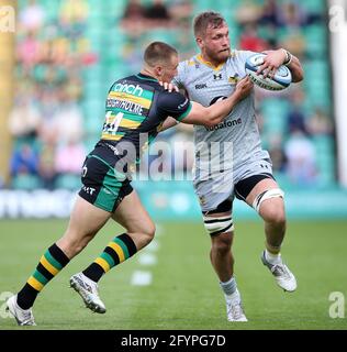 Northampton Saints' Ollie Sleightholme (left) ia tackled by Munster's ...