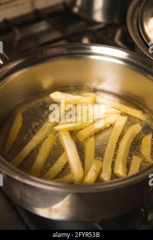 Vertical shot of a pot full of french fries frying in the oil Stock ...