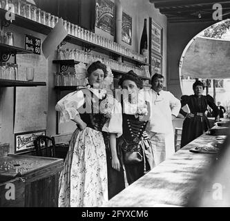 Barmaid standing behind bar counter and holding tray Stock Photo - Alamy