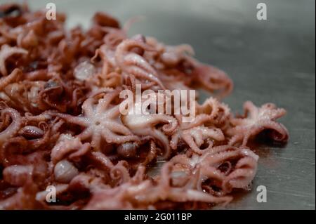 Pickled octopuses lie on a metal table. Ready-made seafood Stock Photo ...
