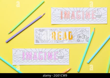 Cute bookmarks with pencils on color background Stock Photo - Alamy