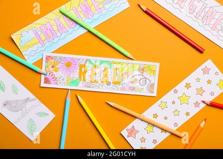 Cute bookmarks with pencils on color background Stock Photo - Alamy