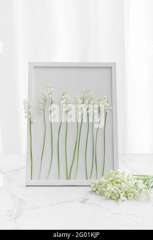 Photo frame with beautiful lily-of-the-valley flowers on light ...