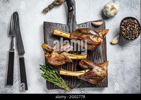 Braised roast Lamb Shanks on a wooden cutting board. White background ...