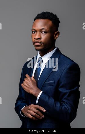 Portrait of African businessman wearing face mask and using laptop ...