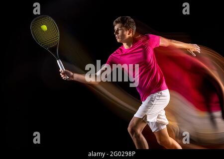 One man, male tennis player training isolated in mixed neon light on ...