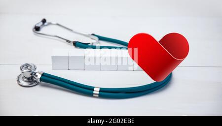 Composition of heart icon over stethoscope and white blocks with copy ...
